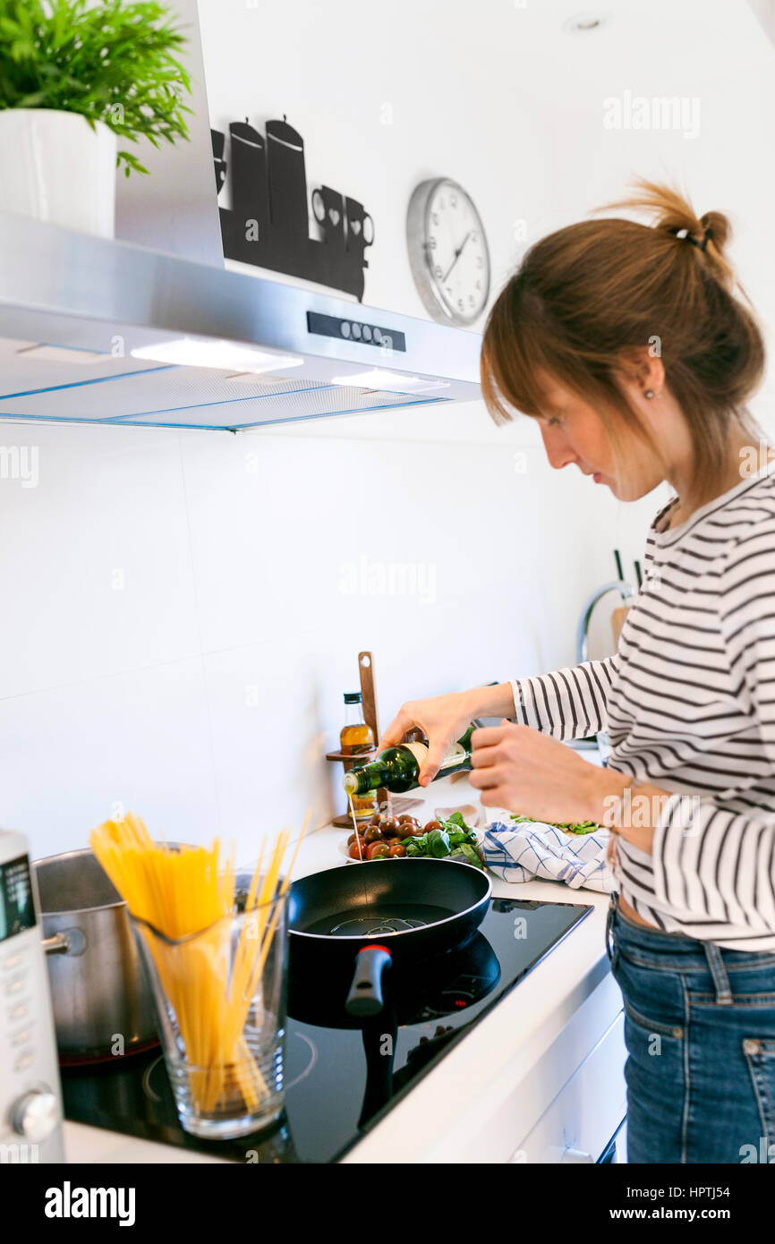 Young woman cooking vegan pasta in her kitchen Stock Photo - Alamy