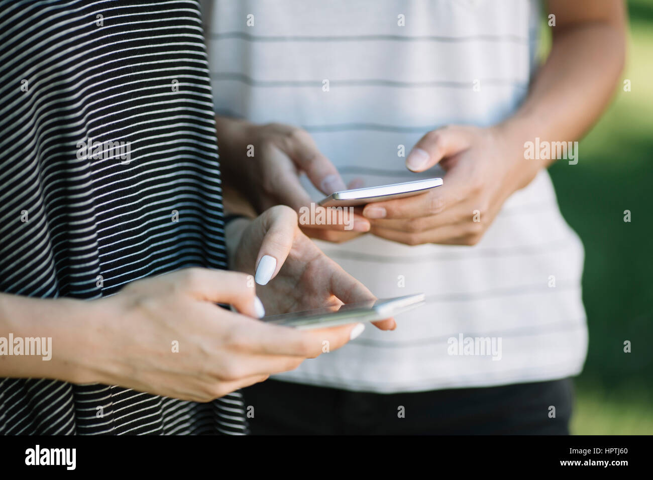 Hands holding smartphones typing hi-res stock photography and images ...