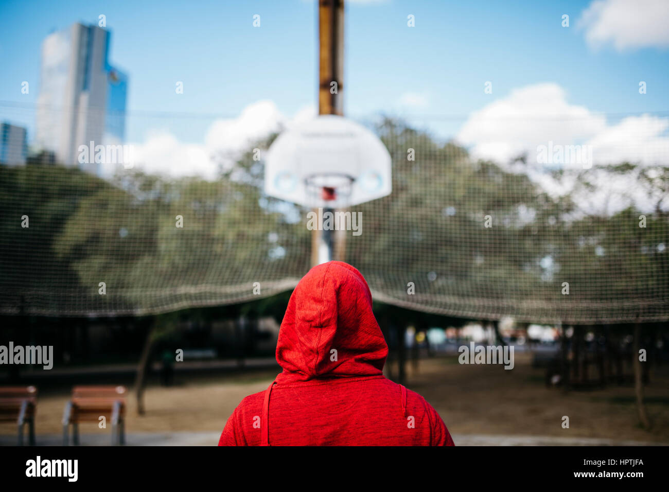Young man wearing red hoodie on a basketball court Stock Photo - Alamy