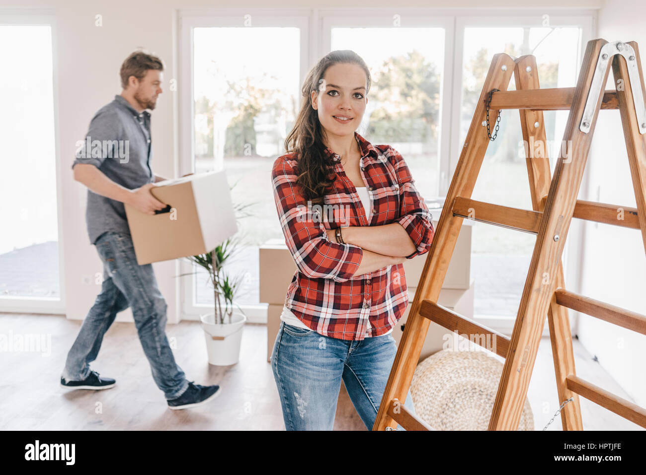 Couple moving house, carrying boxes in new home Stock Photo - Alamy