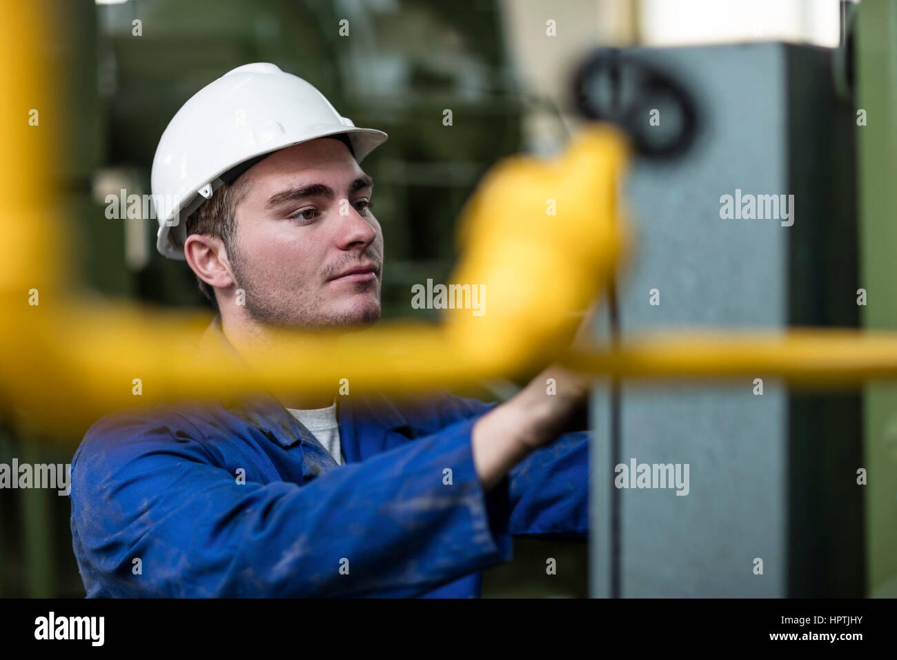 Worker operating machine in factory Stock Photo - Alamy