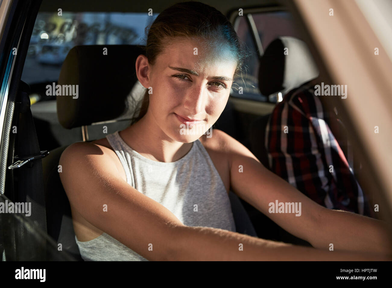Portrait of young car driver looking out of car window Stock Photo - Alamy