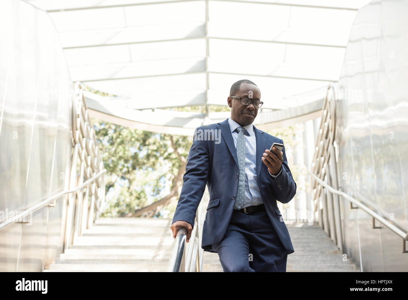Businessman checking cell phone on stairs Stock Photo - Alamy
