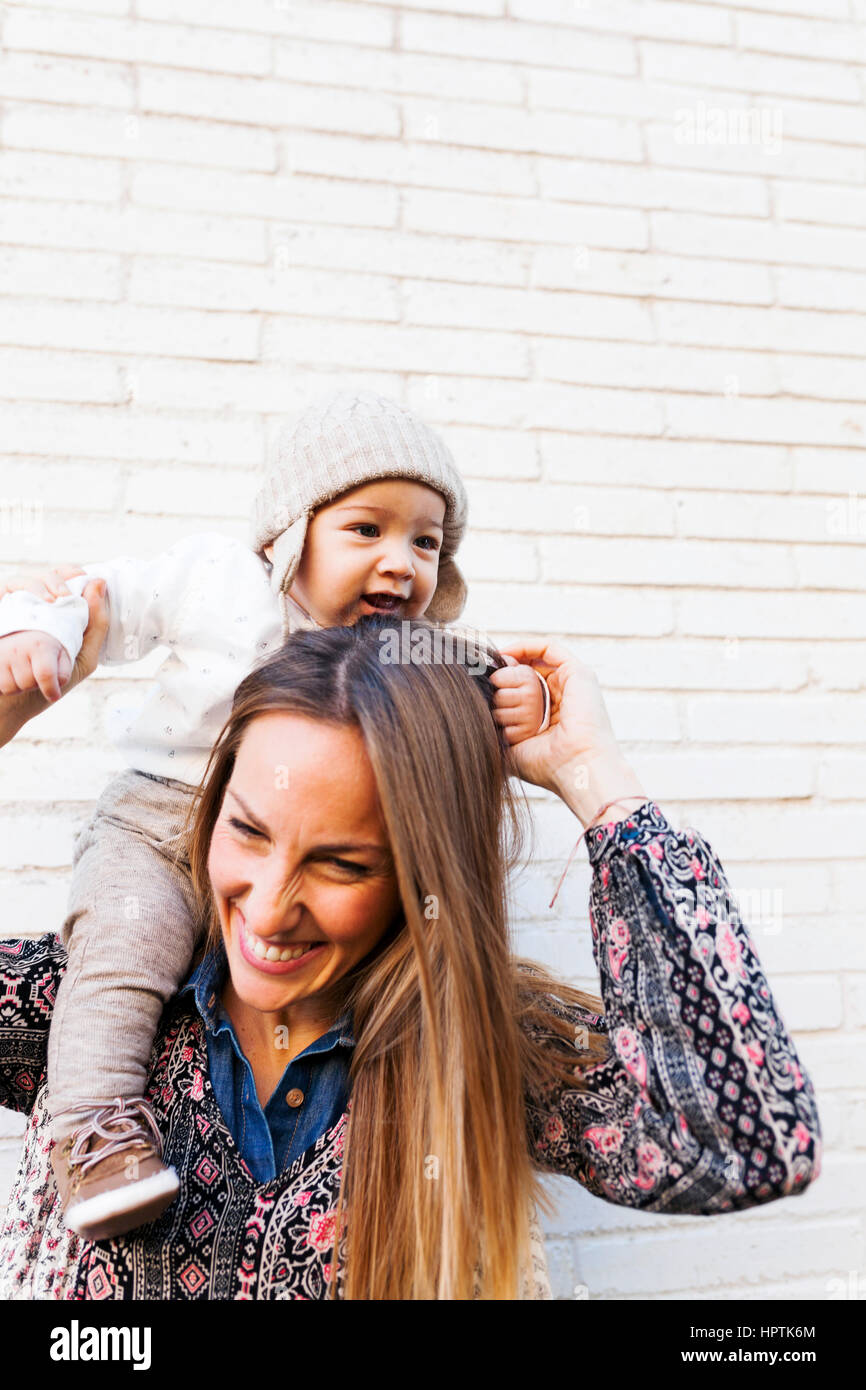 Happy mother holding her baby on shoulders Stock Photo - Alamy