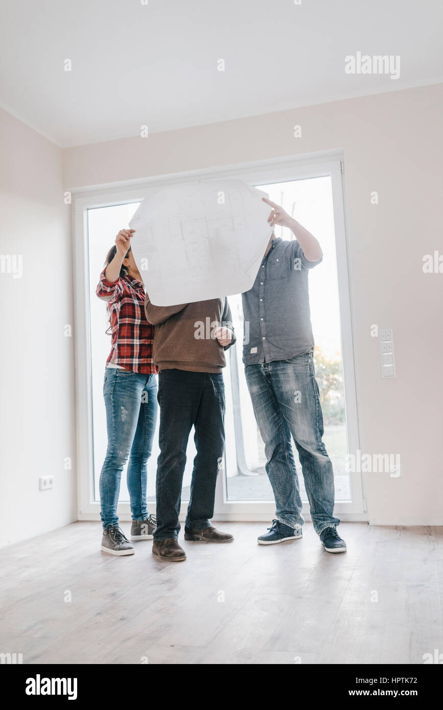 Architect checking construction plan with owners of the new home Stock ...