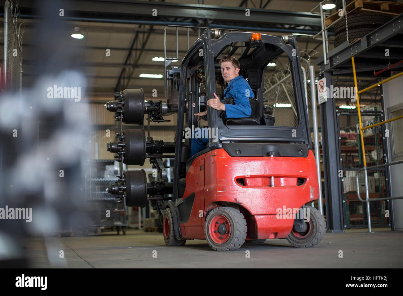 Factory working driving a fork lift in warehouse Stock Photo - Alamy