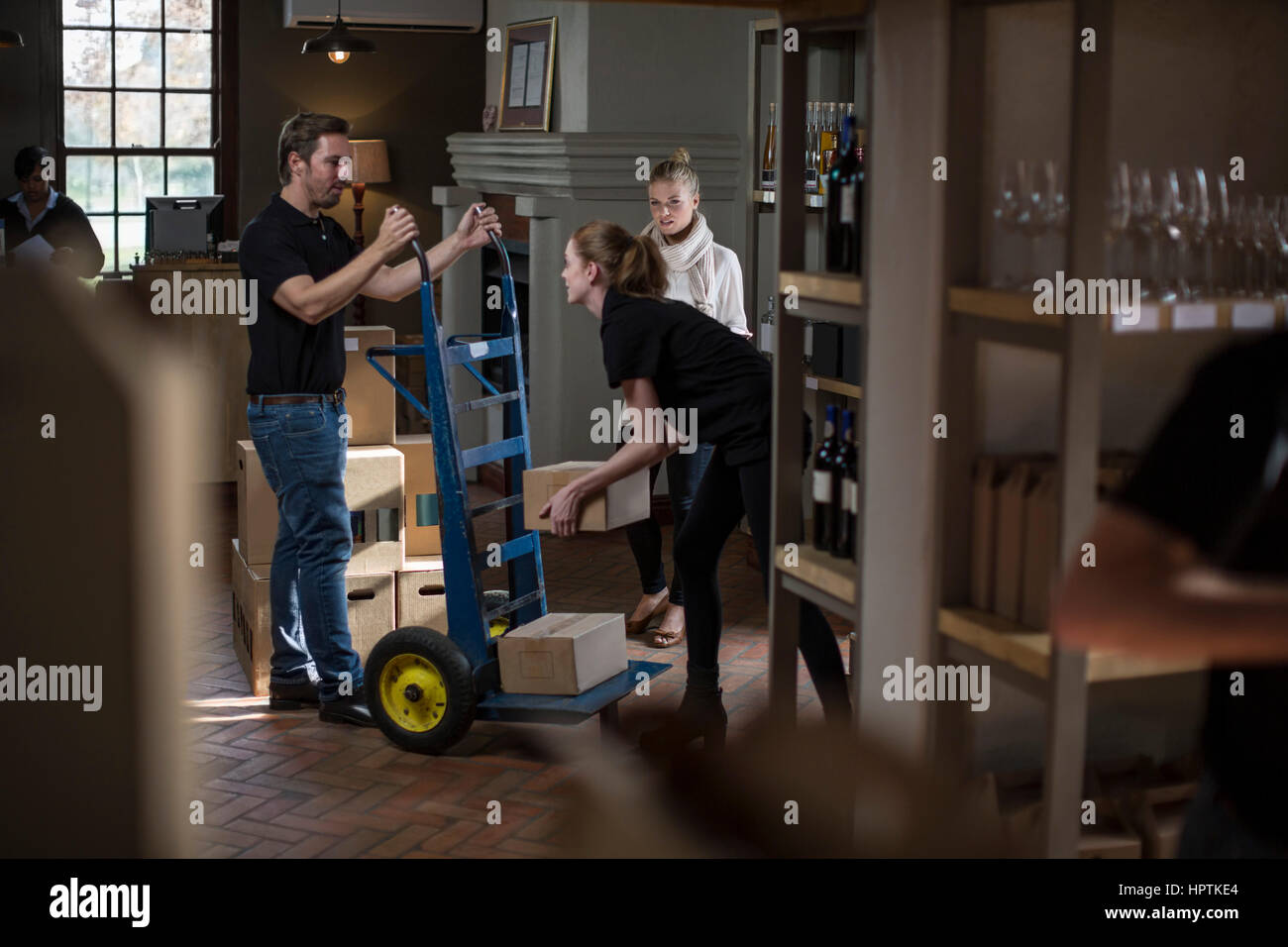 Wine staff with hand truck with boxes of wine stock in wine shop Stock ...