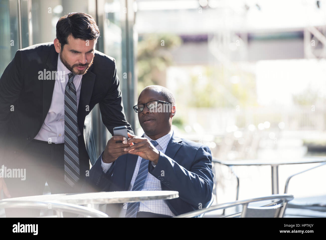 Two businessmen city looking cell phone hi-res stock photography and images - Alamy