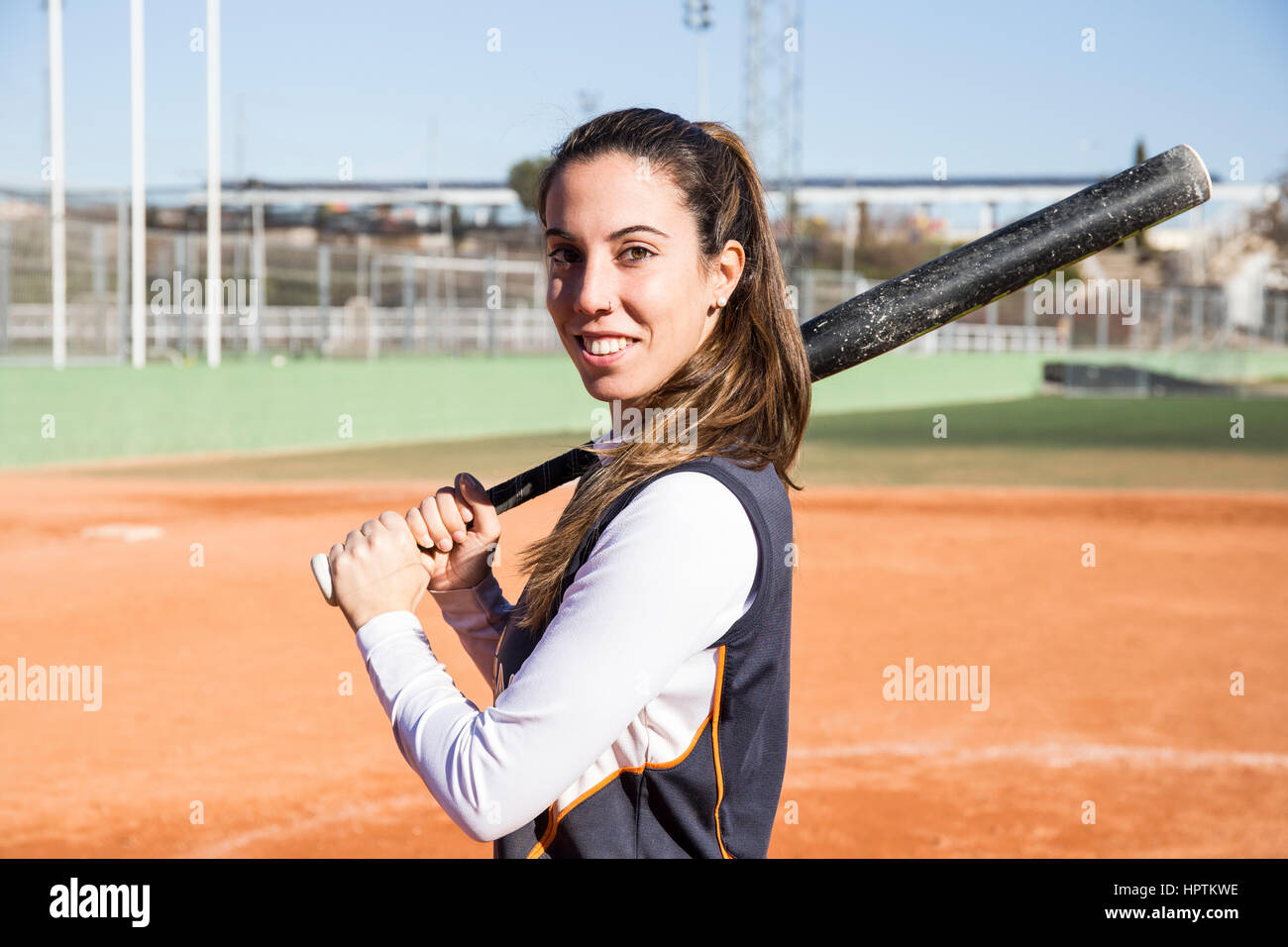 Portrait of smiling female baseball player with a baseball bat Stock ...