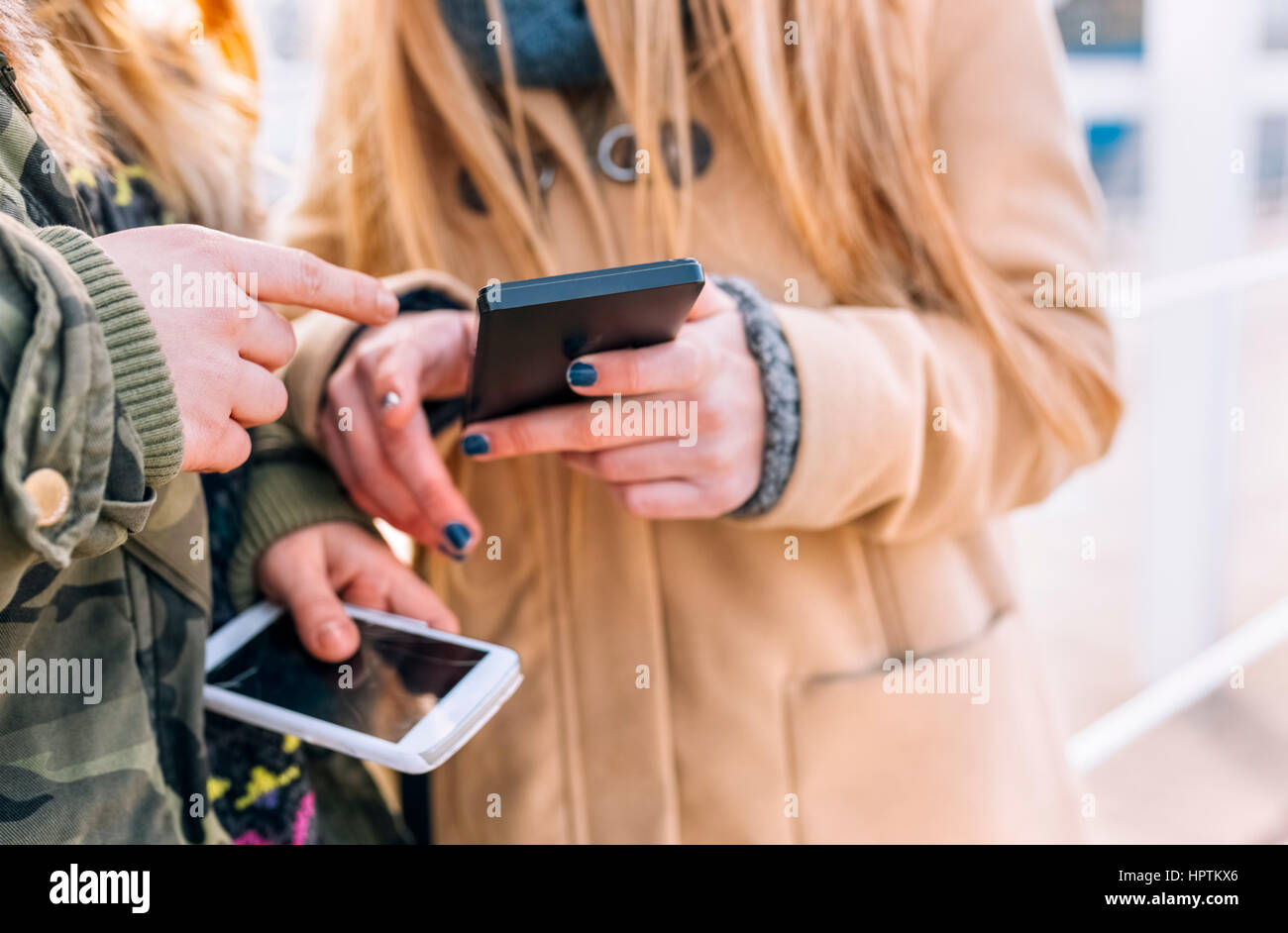 Two friends with their smartphones, partial view Stock Photo - Alamy