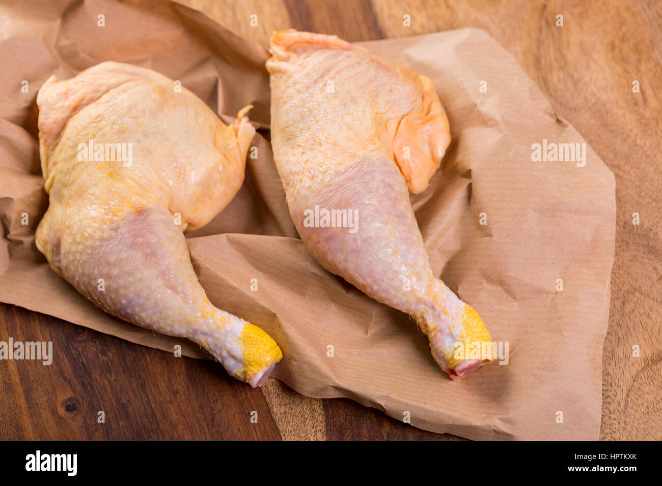 Two chicken legs on brown paper, close-up Stock Photo - Alamy
