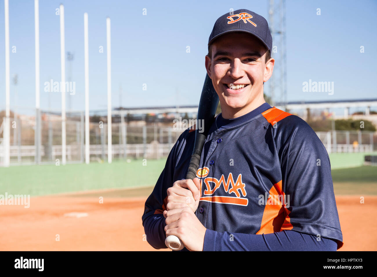 Portrait of smiling baseball player with a baseball bat Stock Photo - Alamy