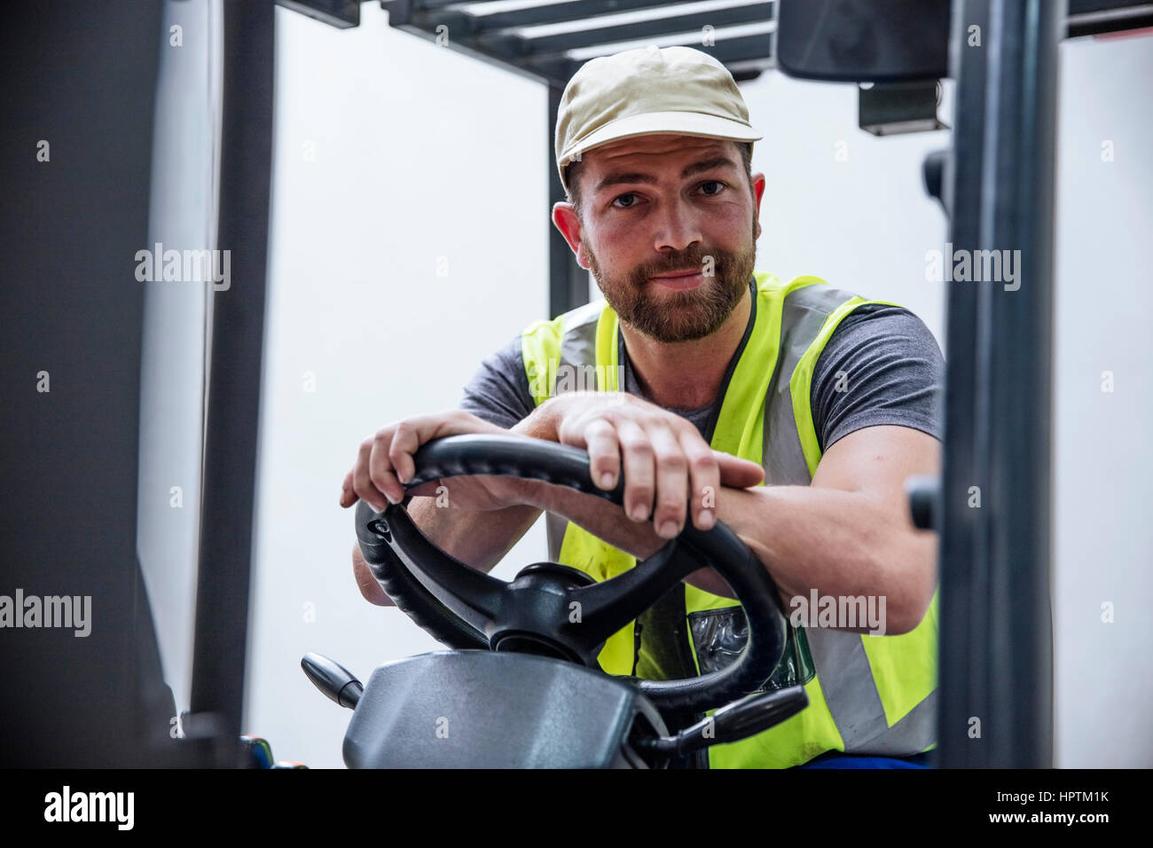 Portrait of confident man on forklift Stock Photo - Alamy