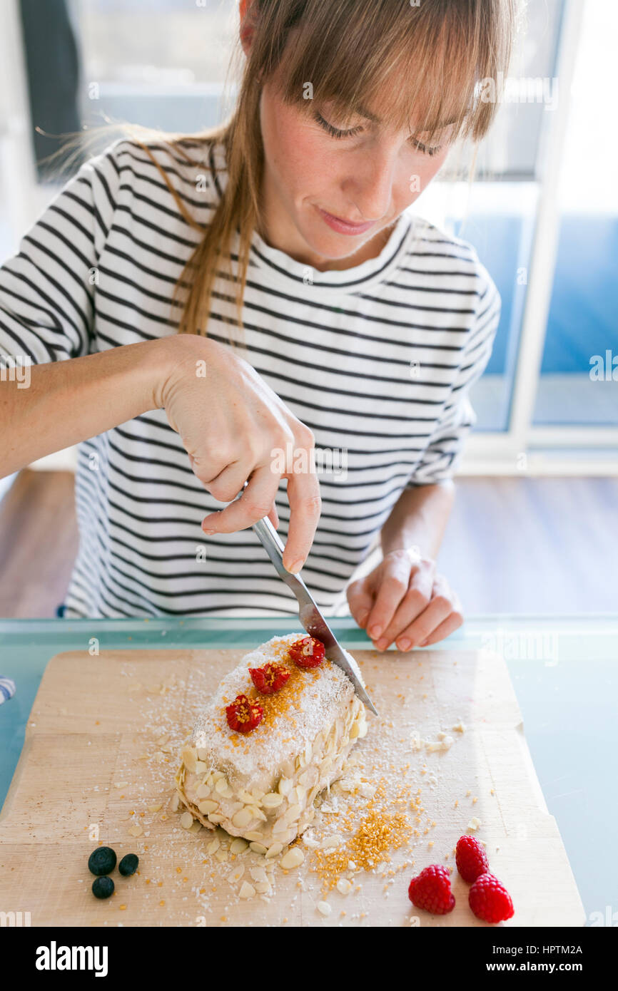 Young woman cutting up vegan cake Stock Photo - Alamy