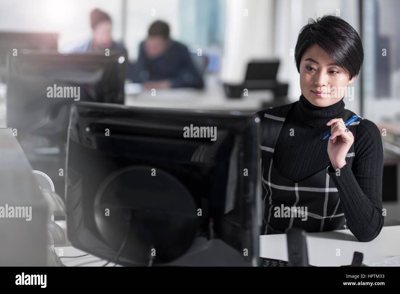 Woman working on computer at desk in office Stock Photo - Alamy