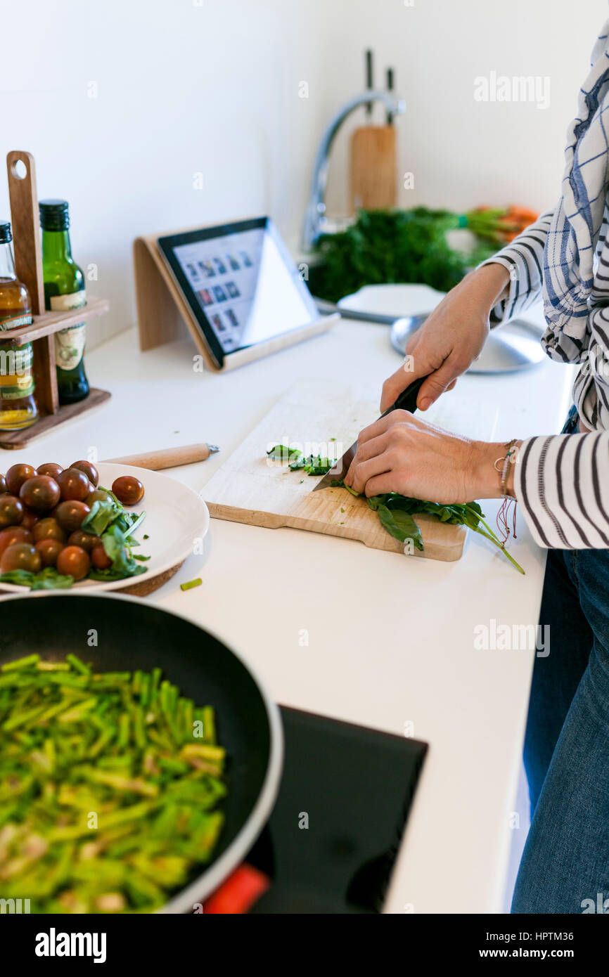 Young woman cooking at home using digital tablet for recipe Stock Photo ...