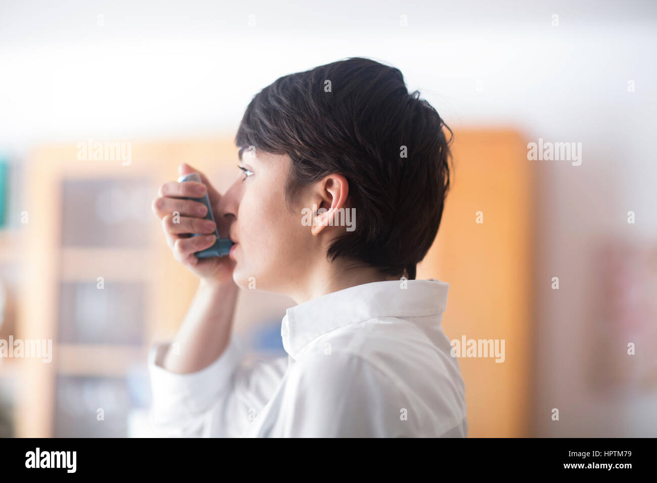 Young woman using inhaler Stock Photo - Alamy