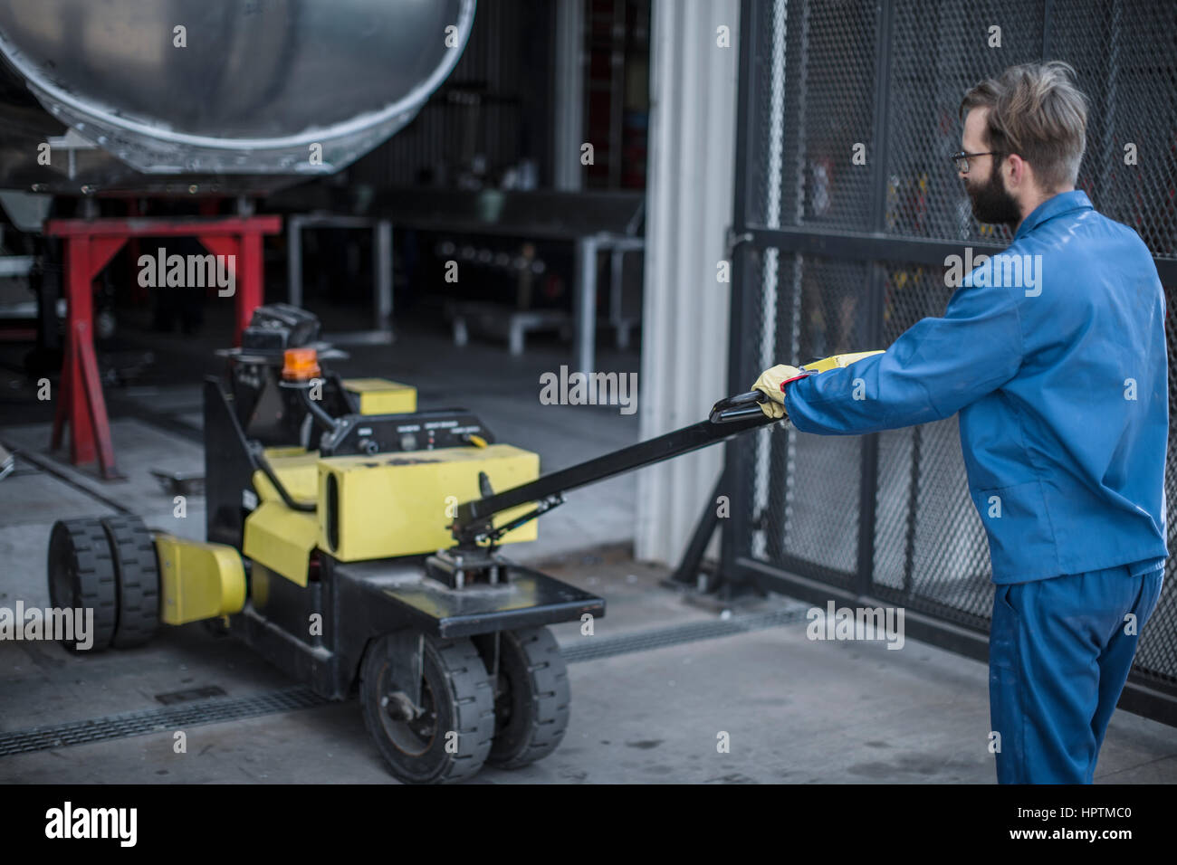 Worker pulling cart factory Stock Photo - Alamy