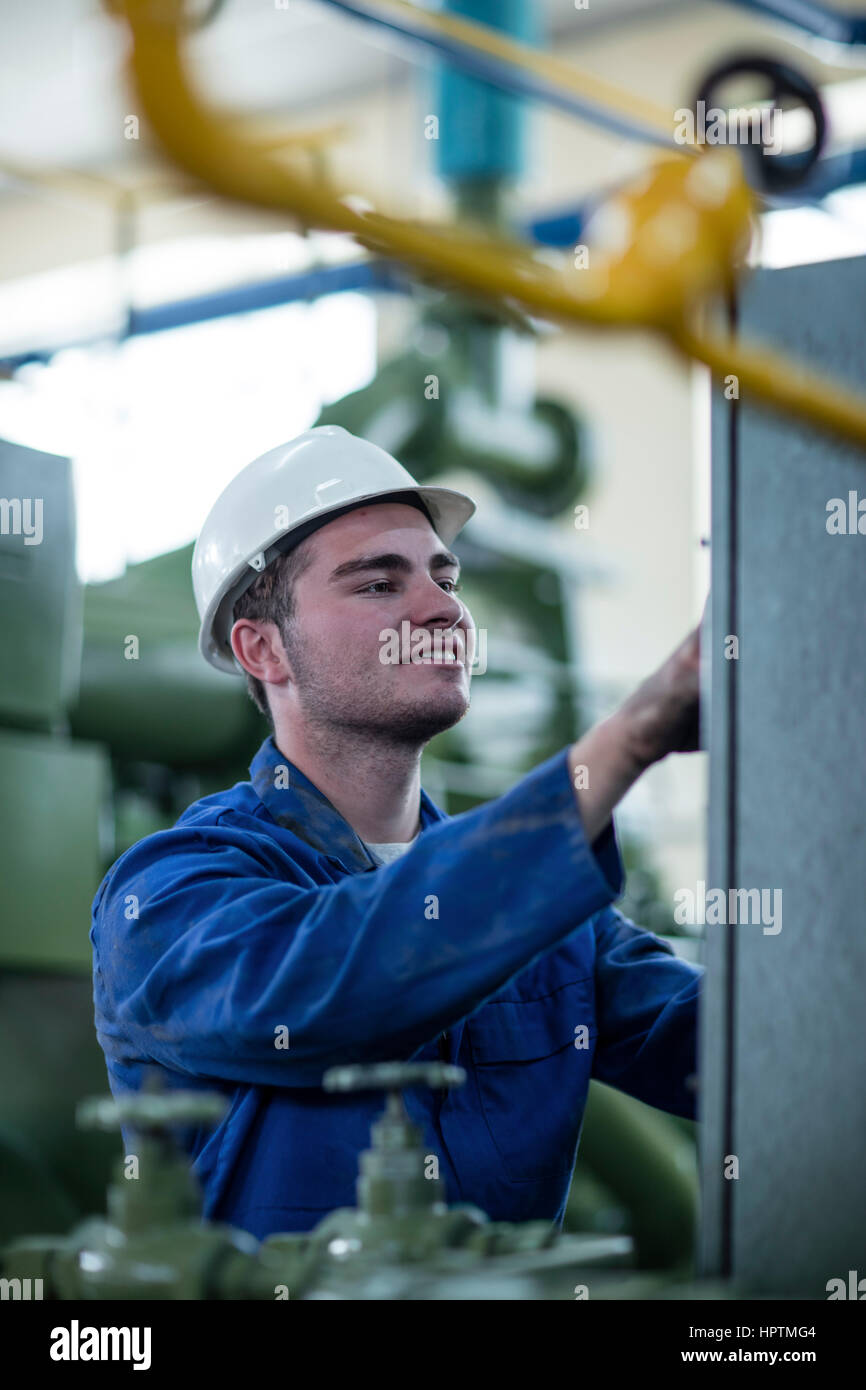 Worker operating machine in factory Stock Photo - Alamy