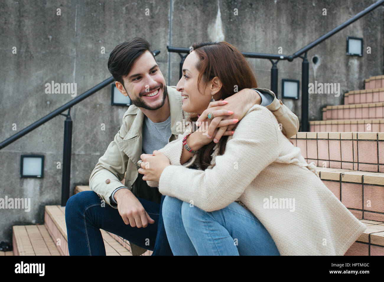 Couple in love sitting on stairs Stock Photo - Alamy