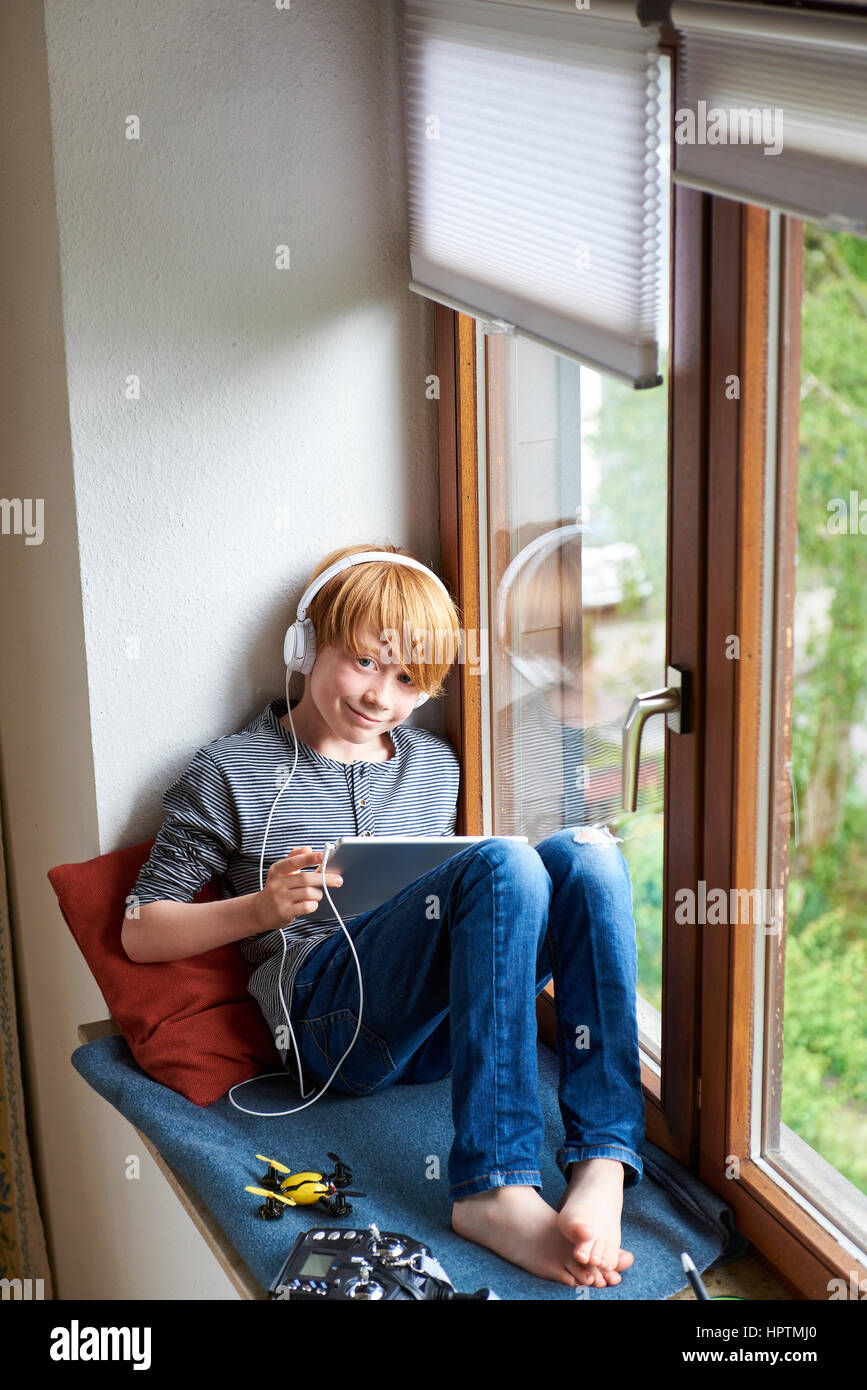 Boy sitting on window sill hi-res stock photography and images - Alamy
