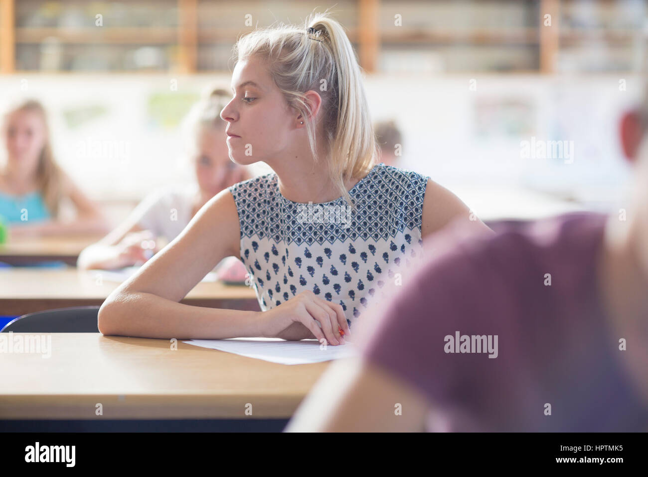 Female student peeking during class test Stock Photo - Alamy