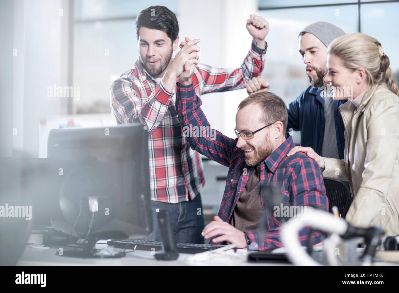 Colleagues in office looking at computer screen cheering Stock Photo ...