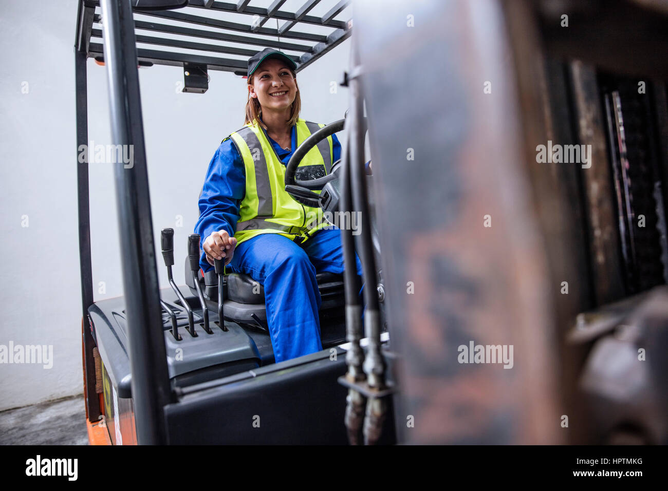 Smiling woman on forklift Stock Photo - Alamy