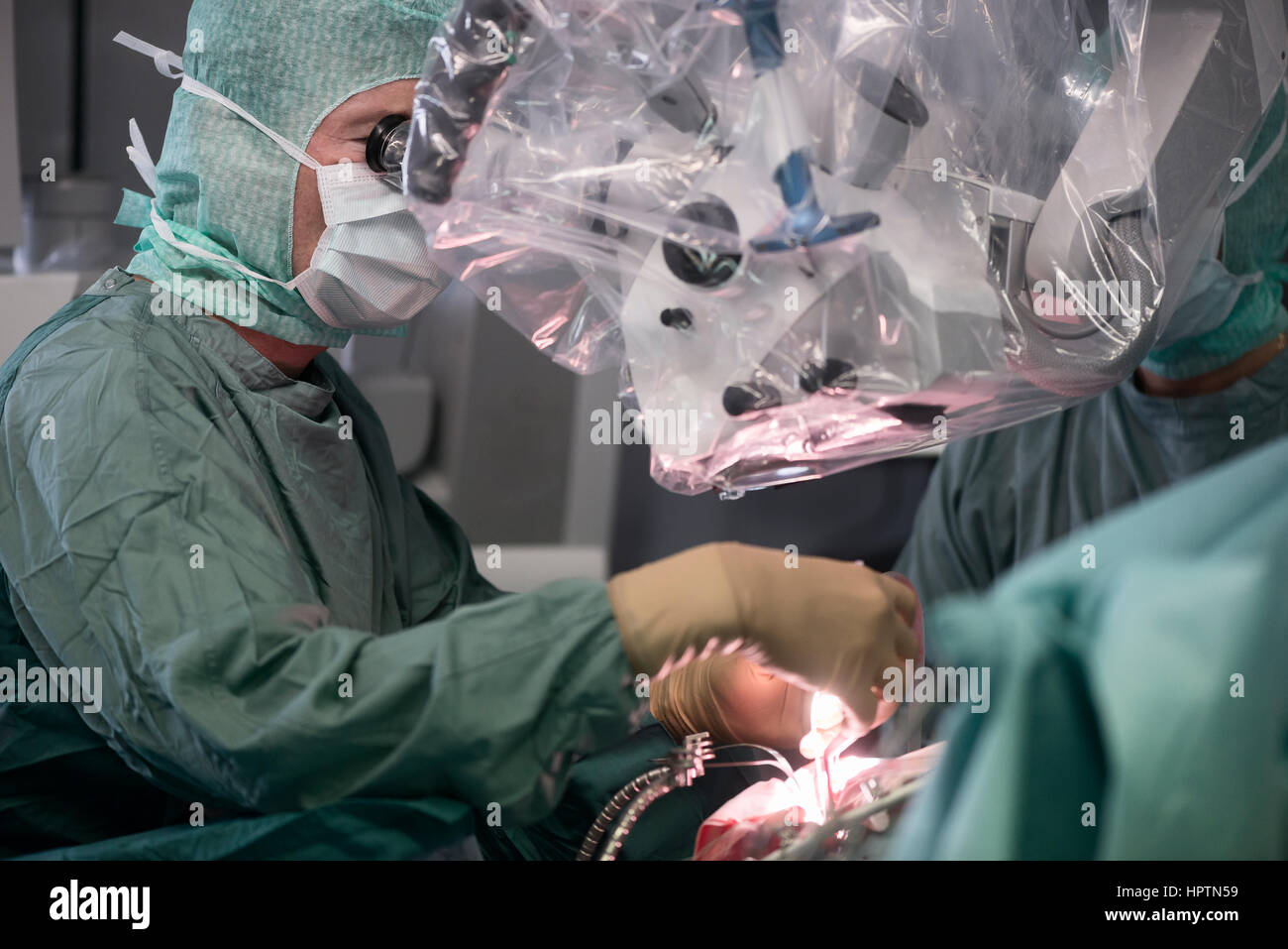 Neurosurgeon looking through microscope during an operation Stock Photo ...