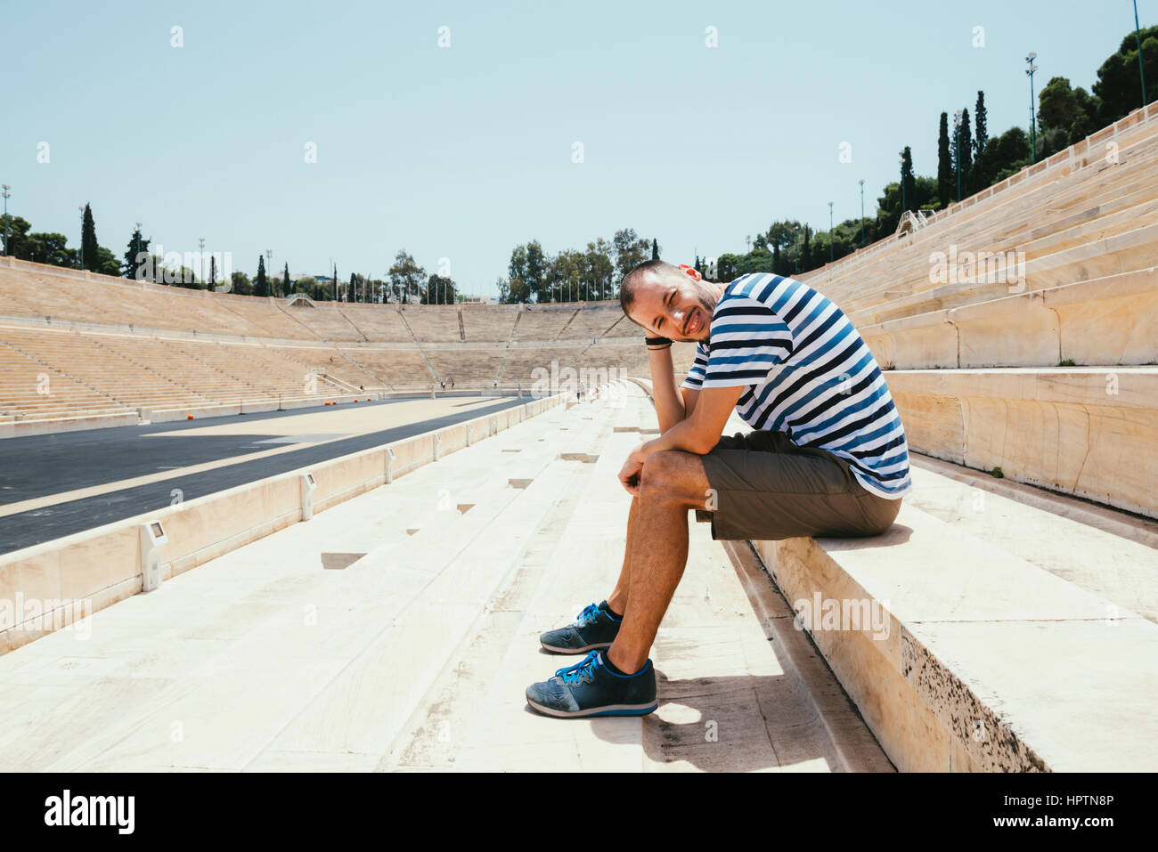 Greece, Athens, man sitting in the stands of the Panathenaic Stadium ...