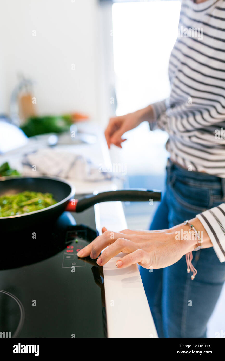 Young woman cooking vegan pasta in her kitchen Stock Photo - Alamy
