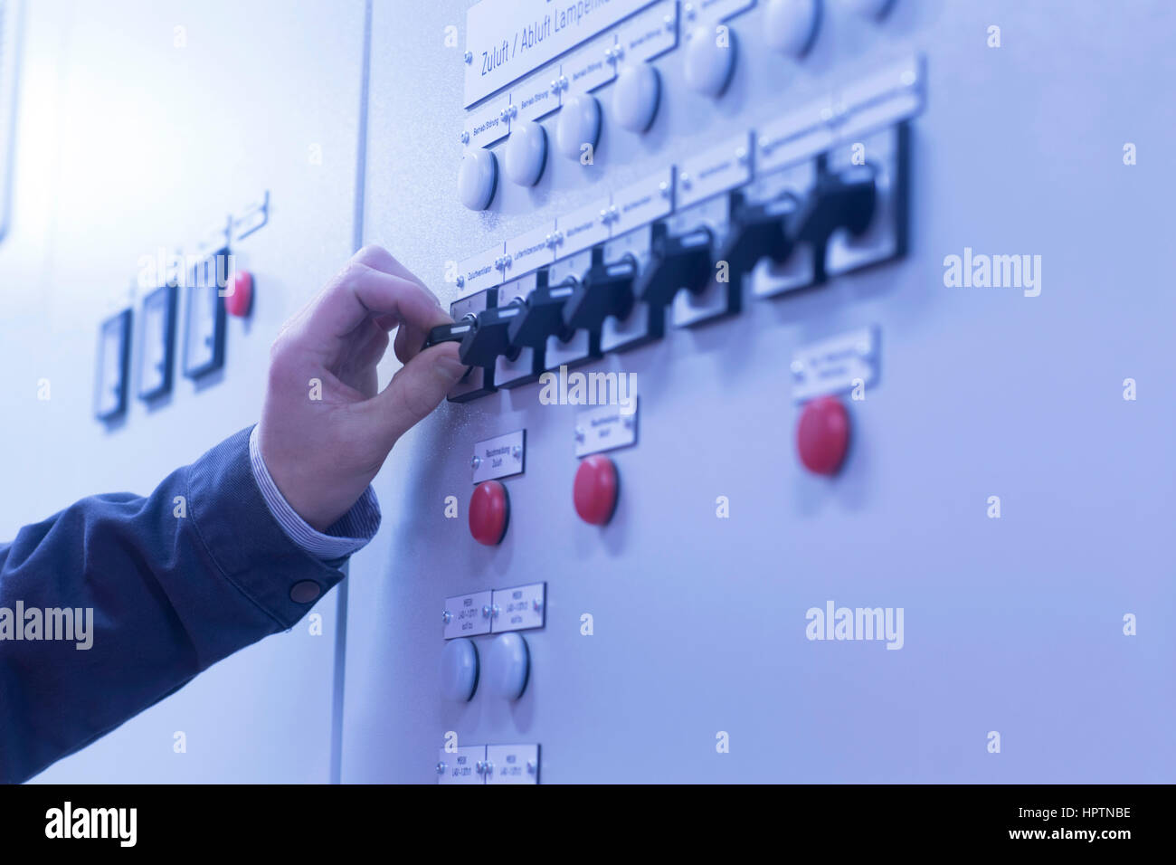 Close-up of hand switching on switch in factory Stock Photo - Alamy