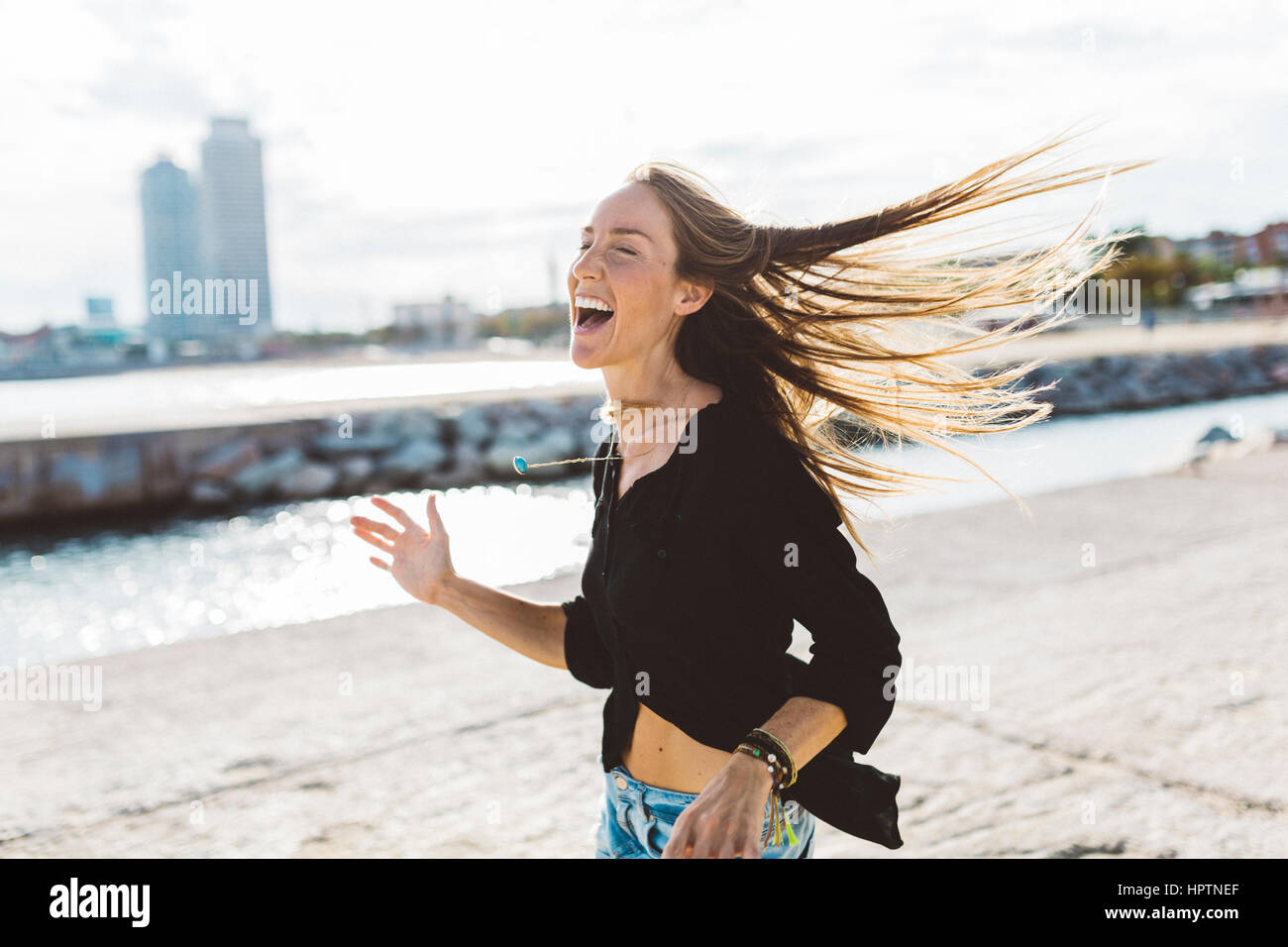 Exuberant young woman at the seafront Stock Photo - Alamy