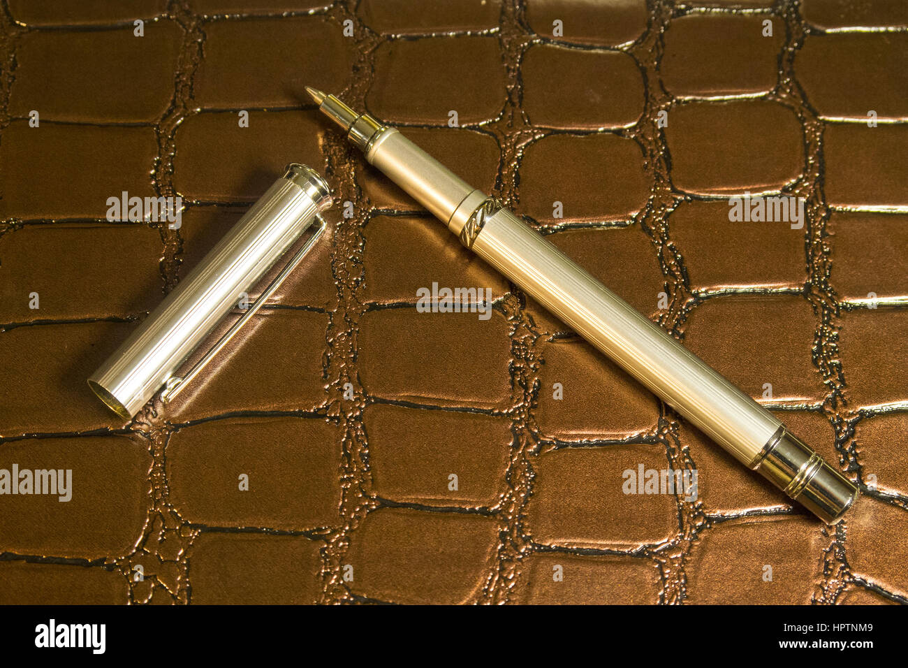 The nice brown notepad and a steel luxury pen Stock Photo - Alamy
