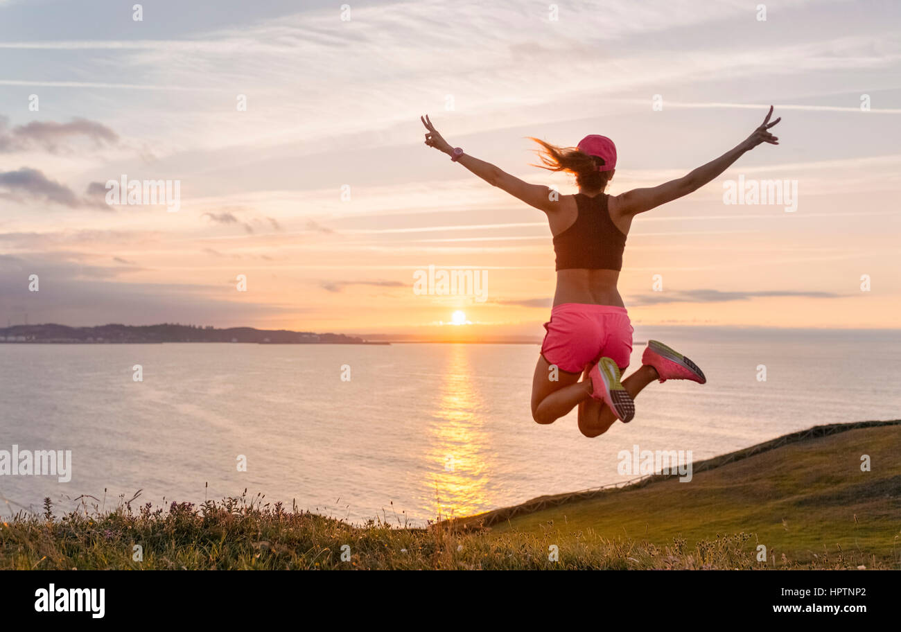 Female athlete jumping for joy Stock Photo - Alamy