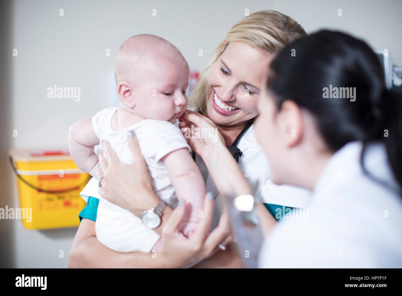 Female pedeatrician holding baby at examination Stock Photo - Alamy
