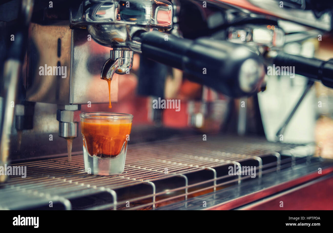 A falling drop of coffee in a Cup. Prepare coffee in coffee machine ...