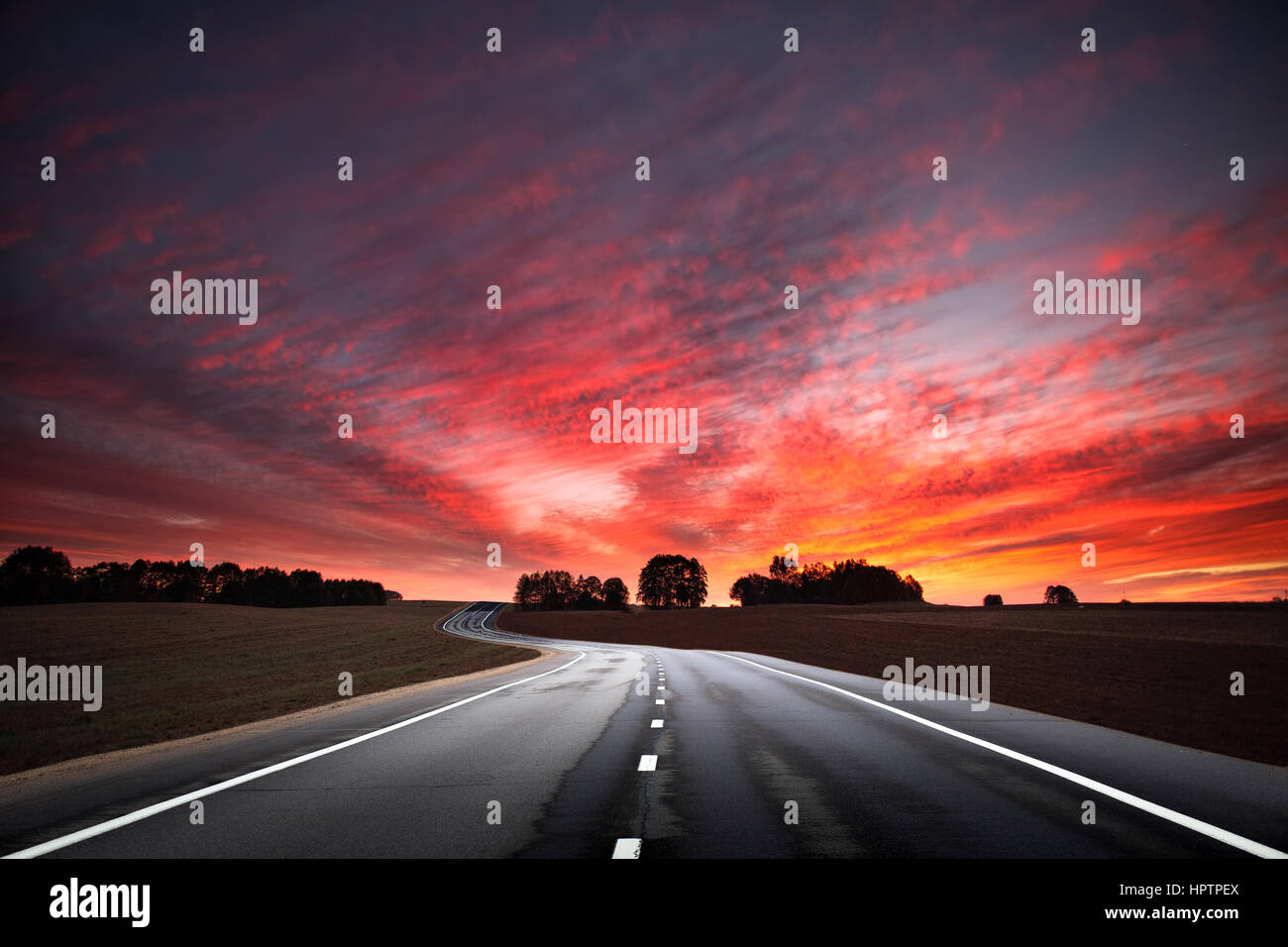 clear road at the sunset colorful cloudy sky Stock Photo - Alamy