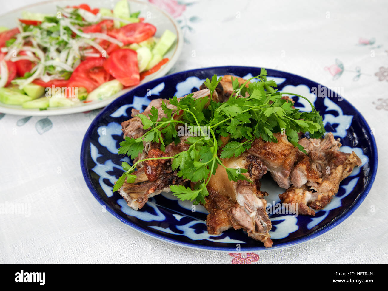 Traditional Uzbek grilled lamb meat with herbs and vegetables Stock ...