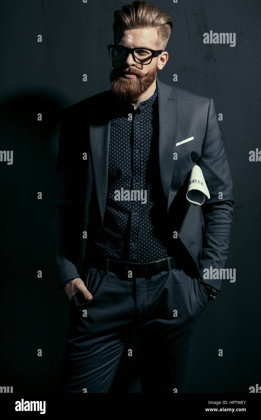 Stylish handsome man in trendy suit standing with hands in pockets and ...