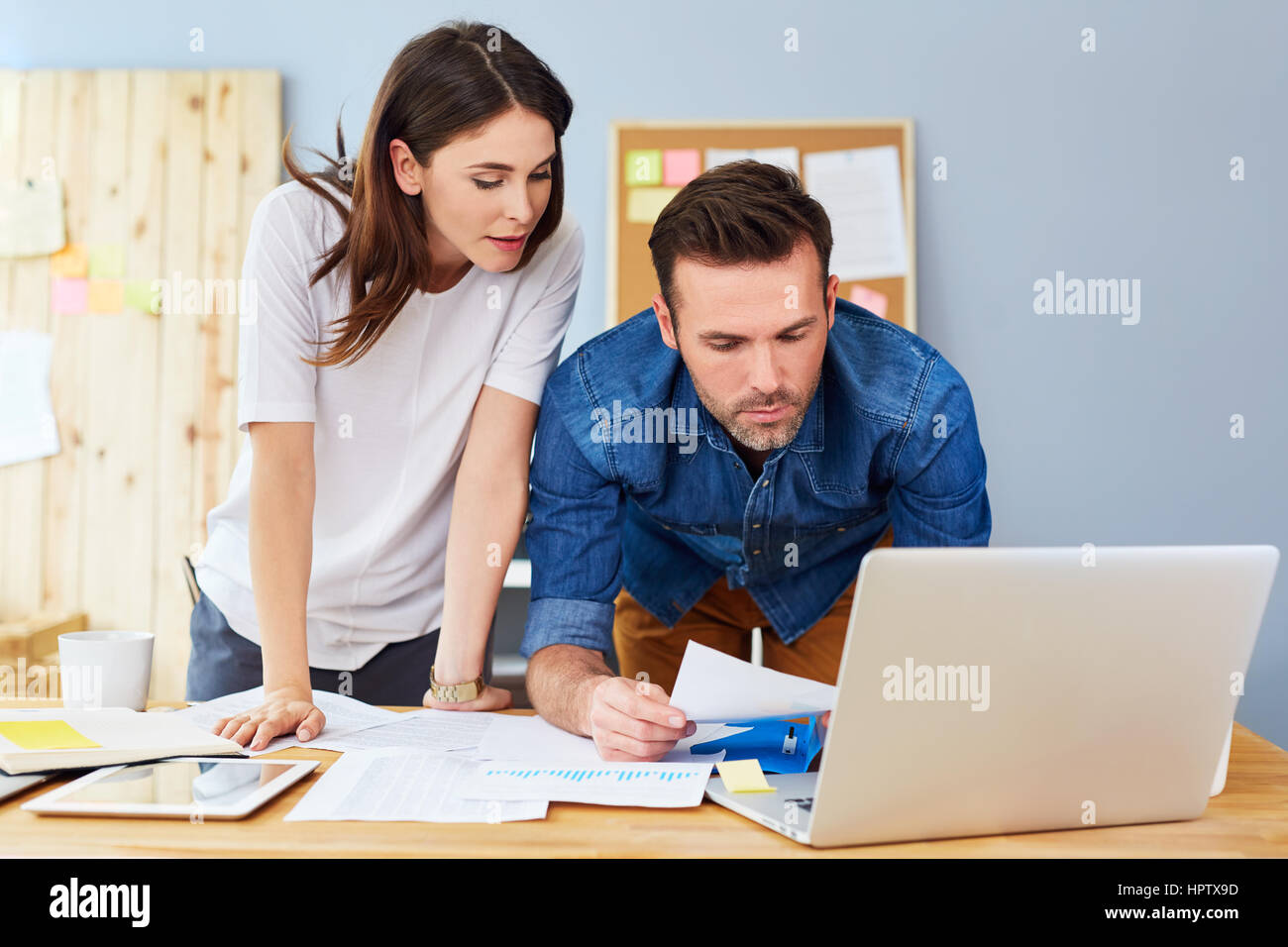 Couple working together at small office with laptop and documents Stock ...