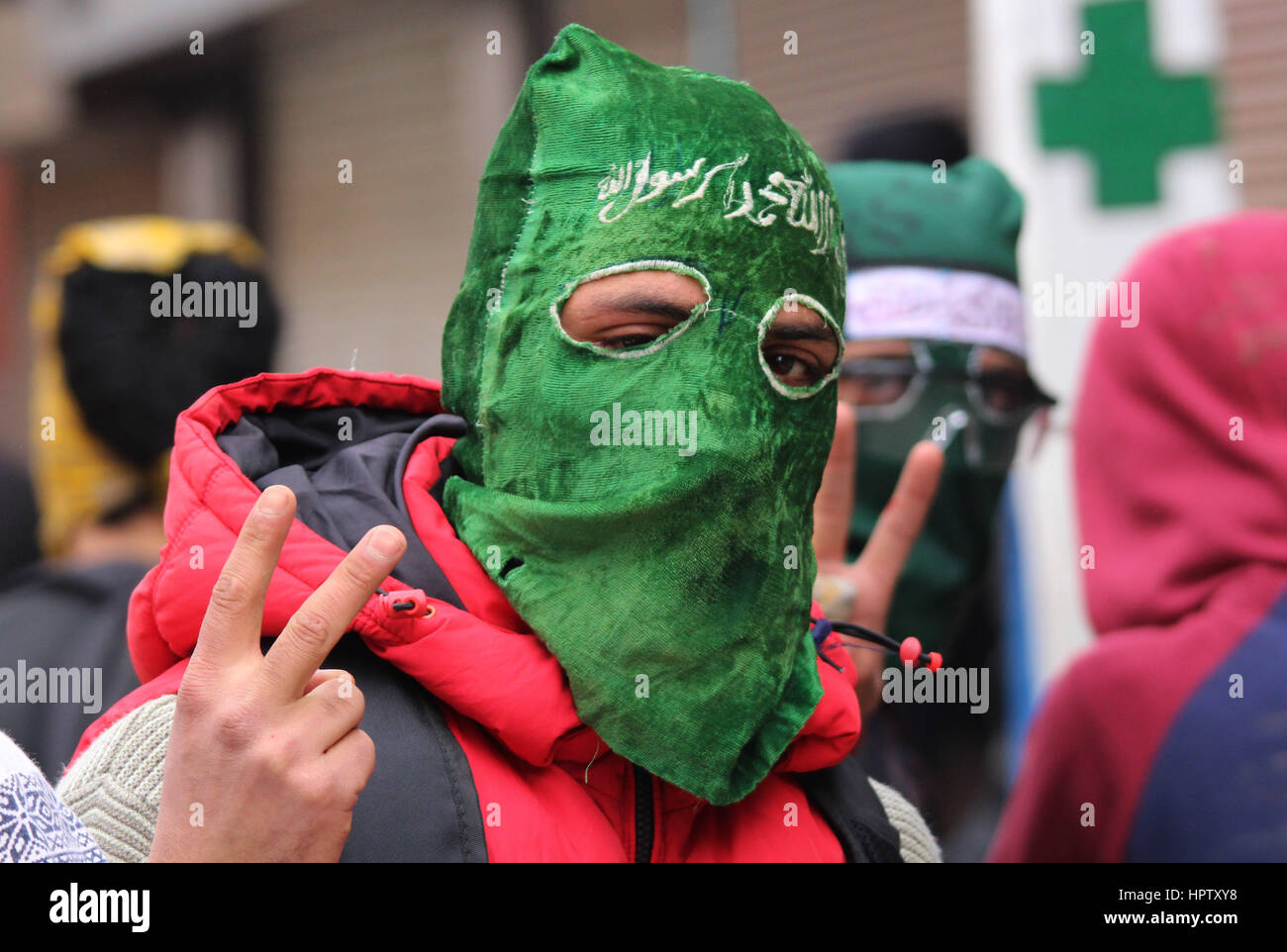 Srinagar, Kashmir. 24th Feb, 2017. A masked youth showing victory sign ...