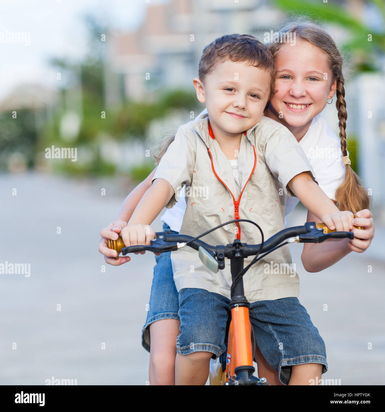 Happy kids with bike standing on the road at the day time. Concept ...