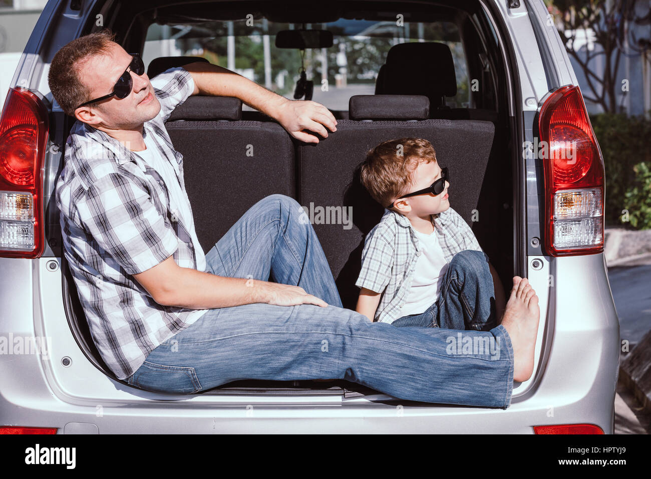 Happy father and son getting ready for road trip on a sunny day ...