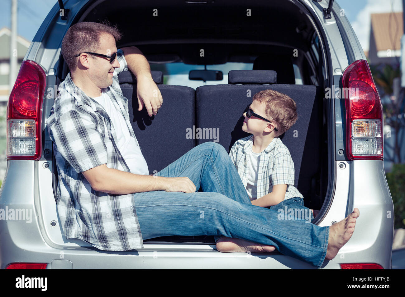 Happy father and son getting ready for road trip on a sunny day ...