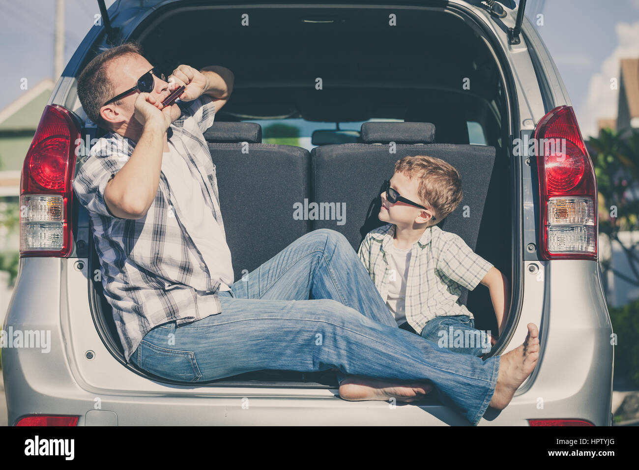 Happy father and son getting ready for road trip on a sunny day ...