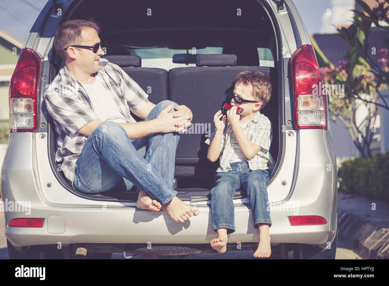 Happy father and son getting ready for road trip on a sunny day ...