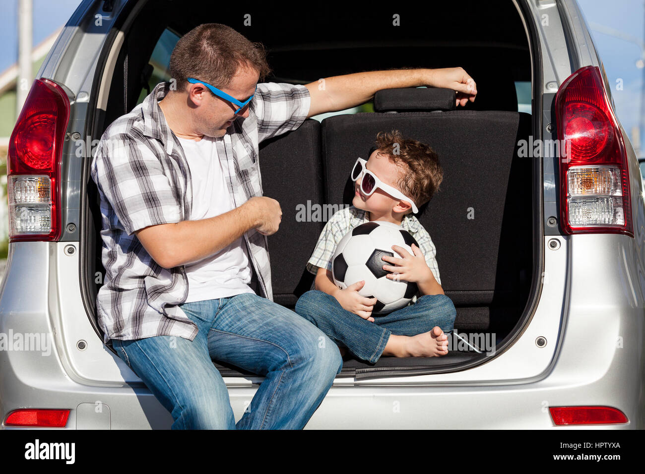 Happy father and son getting ready for road trip on a sunny day ...
