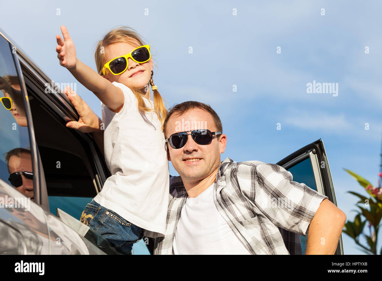 Happy father and daughter getting ready for road trip on a sunny day ...