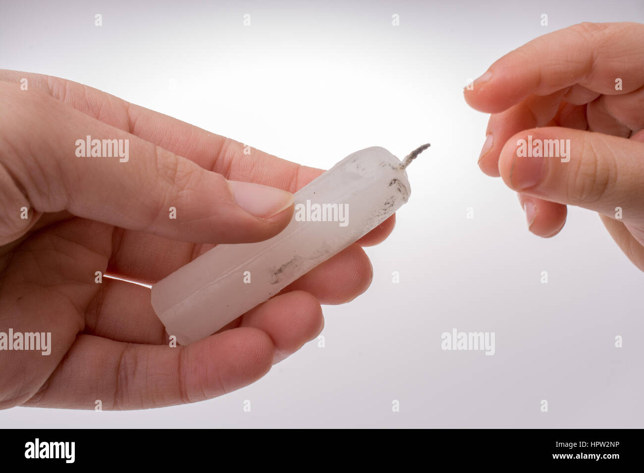 White candle stick in hand on a white background Stock Photo - Alamy